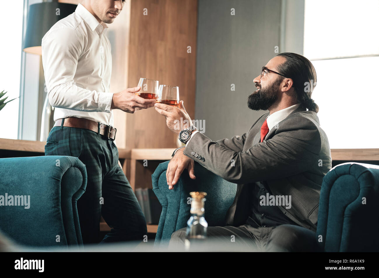 Young employee joining his boss in the restaurant drinking whisky Stock ...