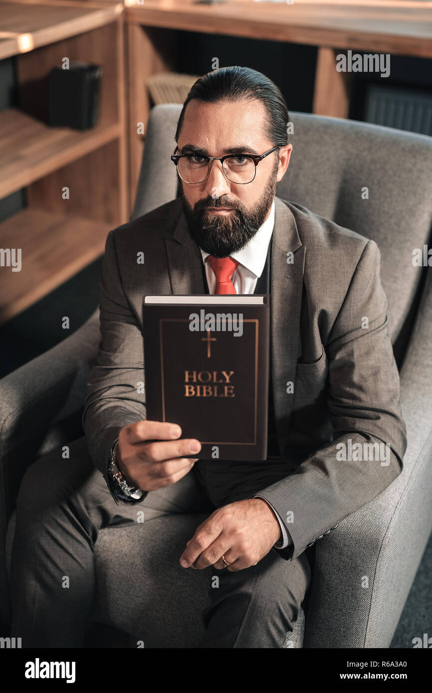Dark-haired bearded man holding the Holy Bible Stock Photo - Alamy