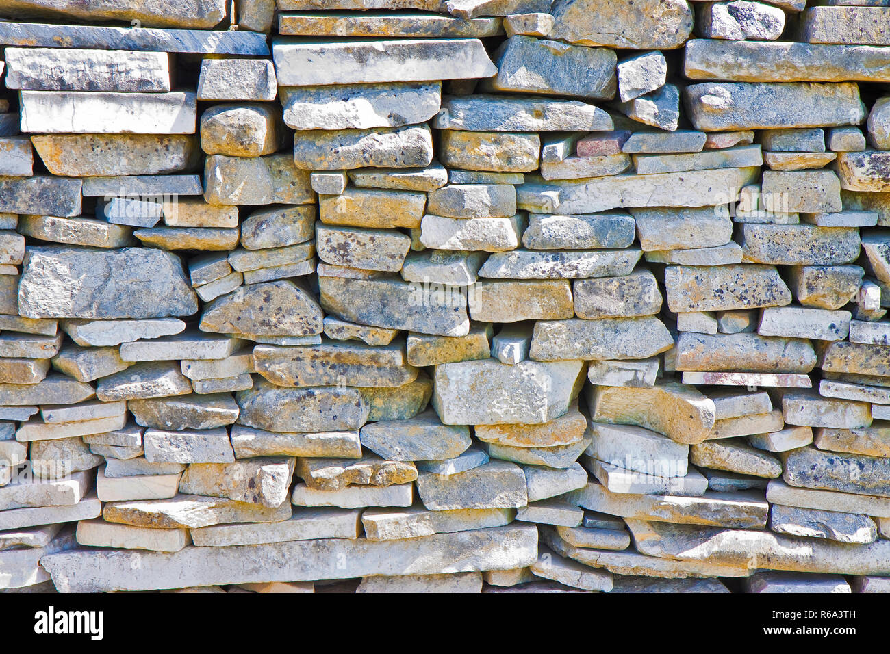 Stone wall built with blocks and marble slabs simply placed over one ...