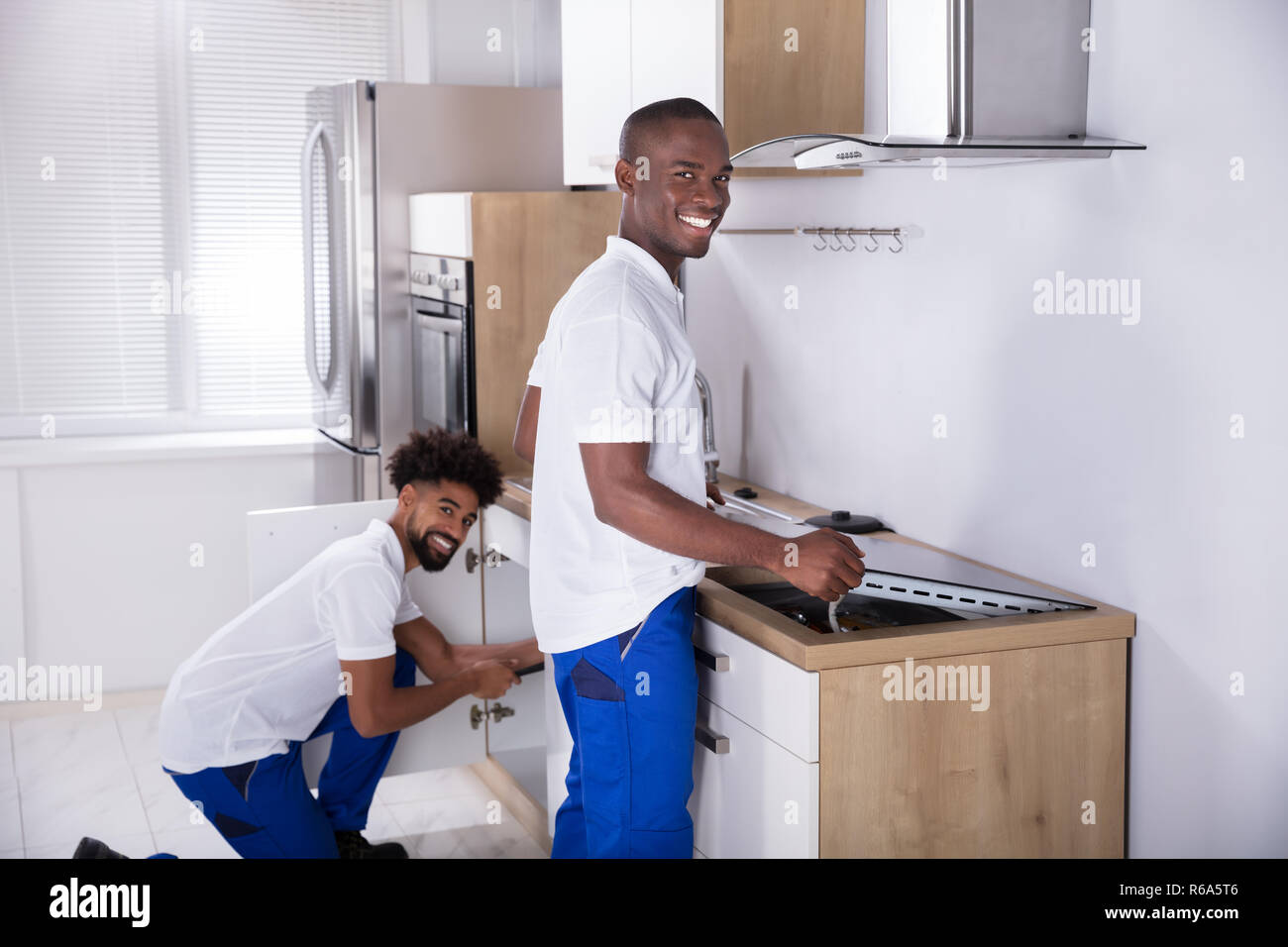 Two men fixing in kitchen hi-res stock photography and images - Alamy