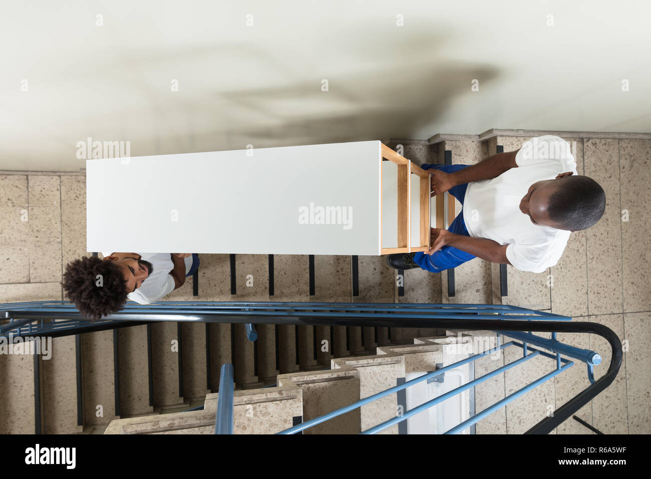 Young Movers Carrying Shelf While Climbing Steps Stock Photo - Alamy