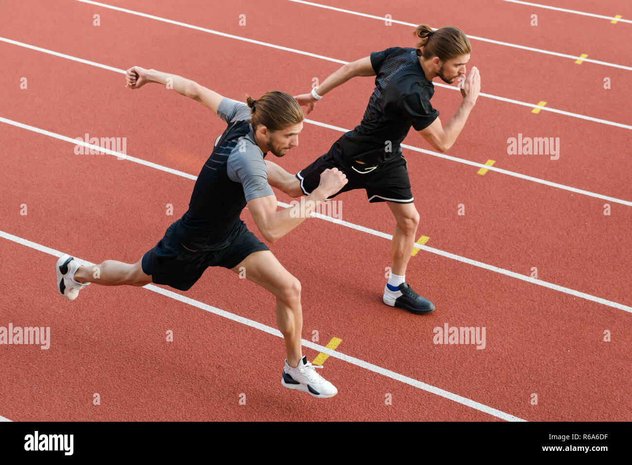 Image of young two twins sportsmen brothers running at the stadium ...