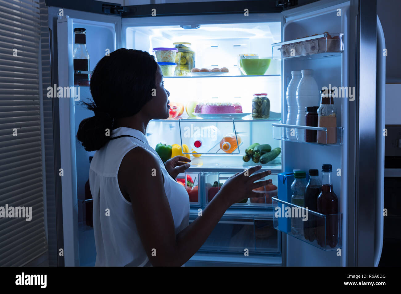 Woman taking cake from fridge hi-res stock photography and images - Alamy