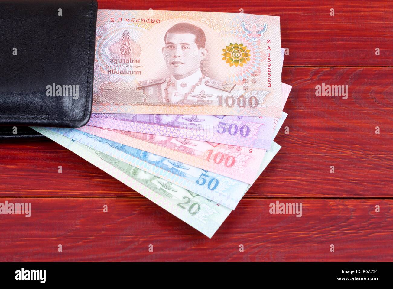 Thai Baht in the black wallet Stock Photo - Alamy