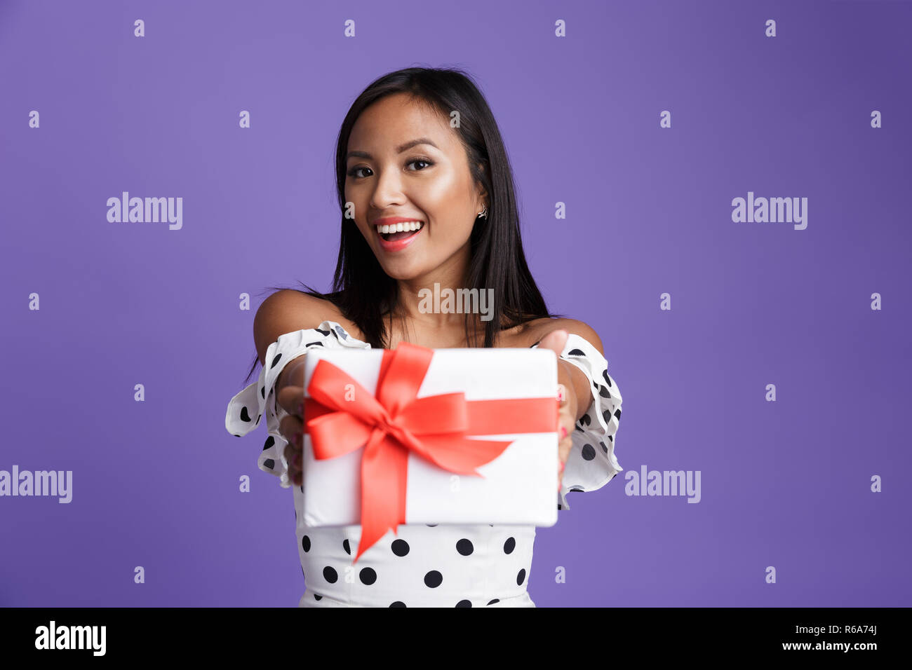 Portrait of a delighted asian woman standing isolated over violet ...
