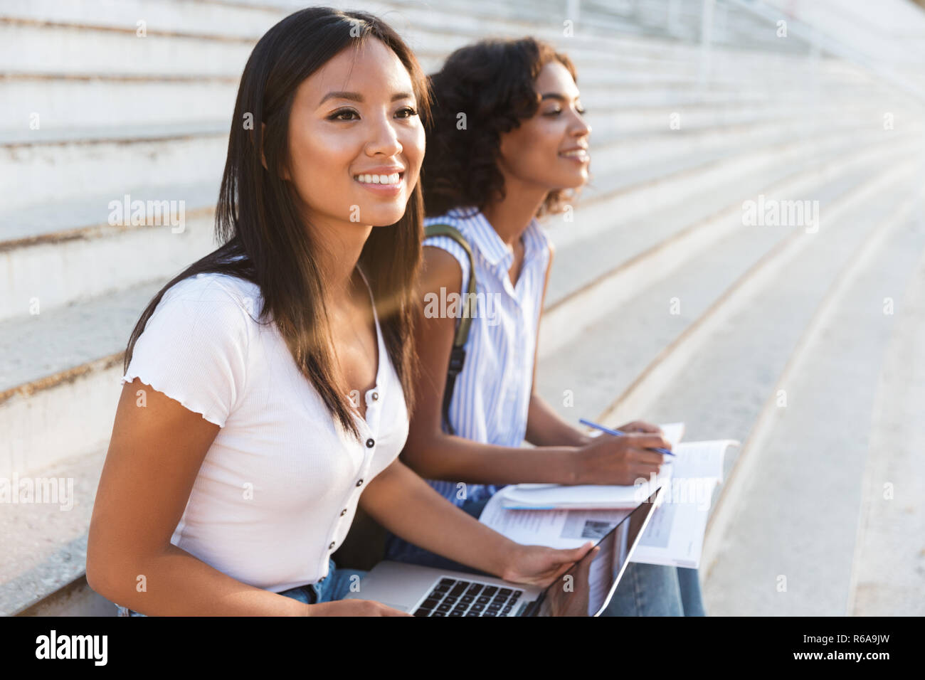 Two happy young multhiethic students girls studying outdoors Stock ...