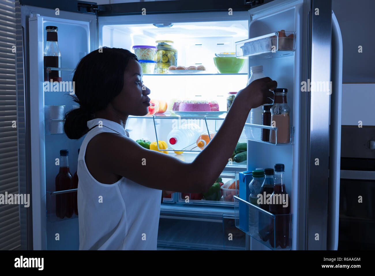 Woman taking cake from fridge hi-res stock photography and images - Alamy