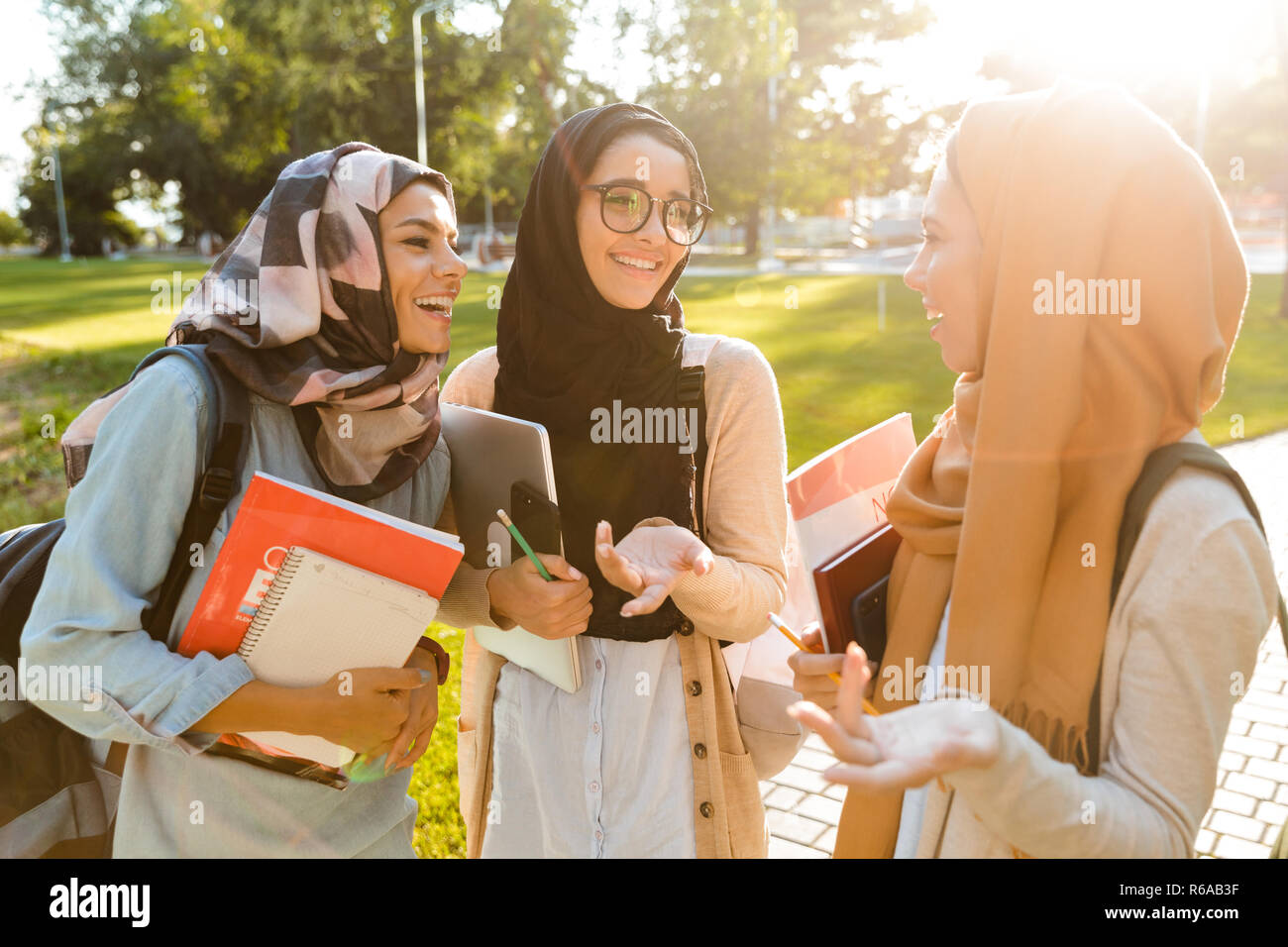 Image of happy friends muslim sisters women walking outdoors holding ...