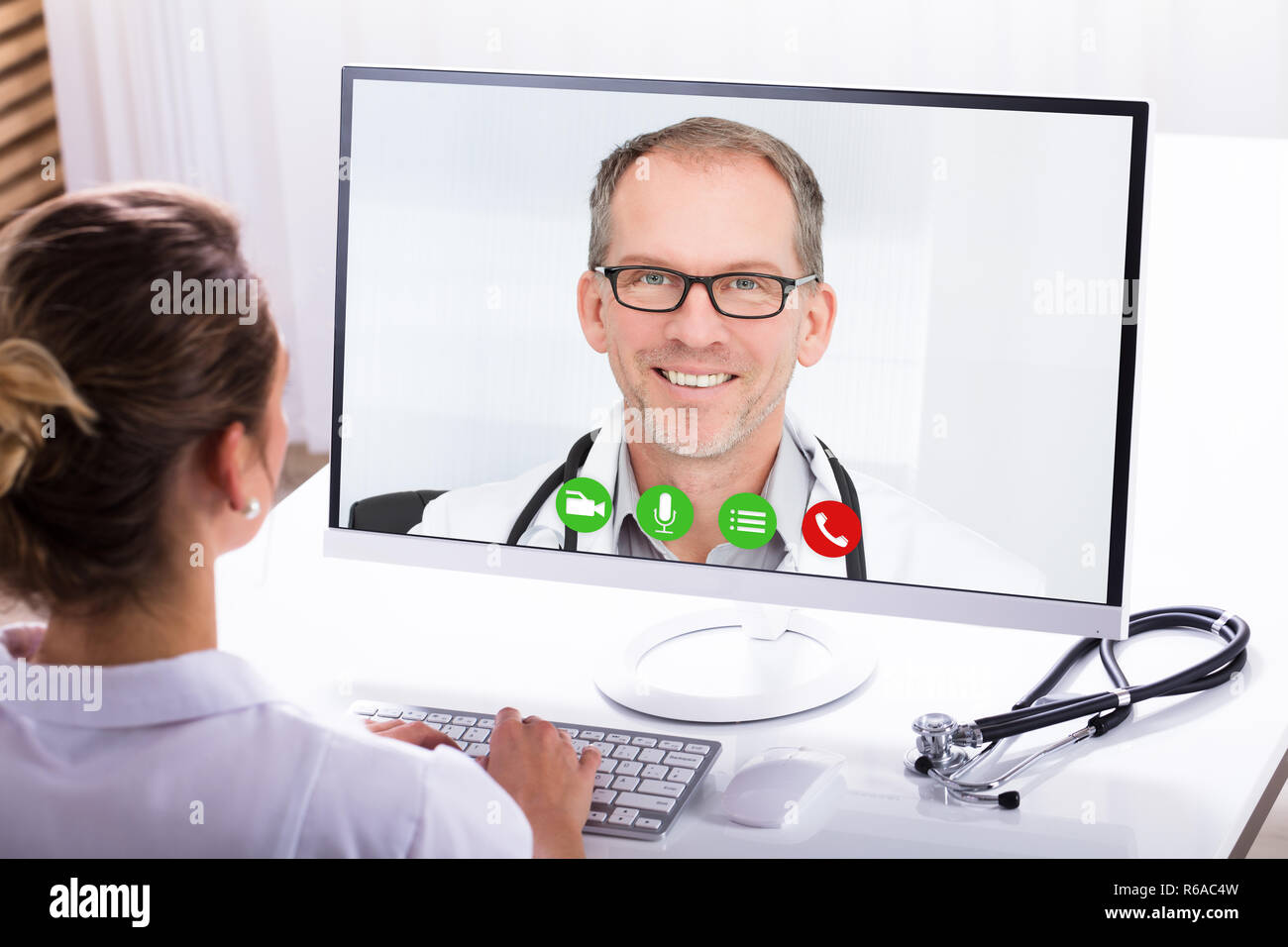 Woman Video Conferencing With A Male Doctor Stock Photo - Alamy