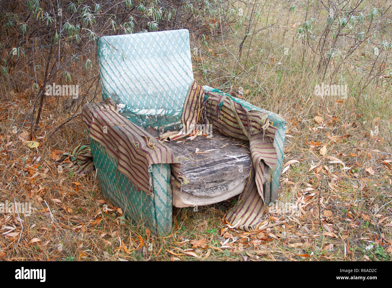 Old discarded and tattered armchair in the grass Stock Photo - Alamy