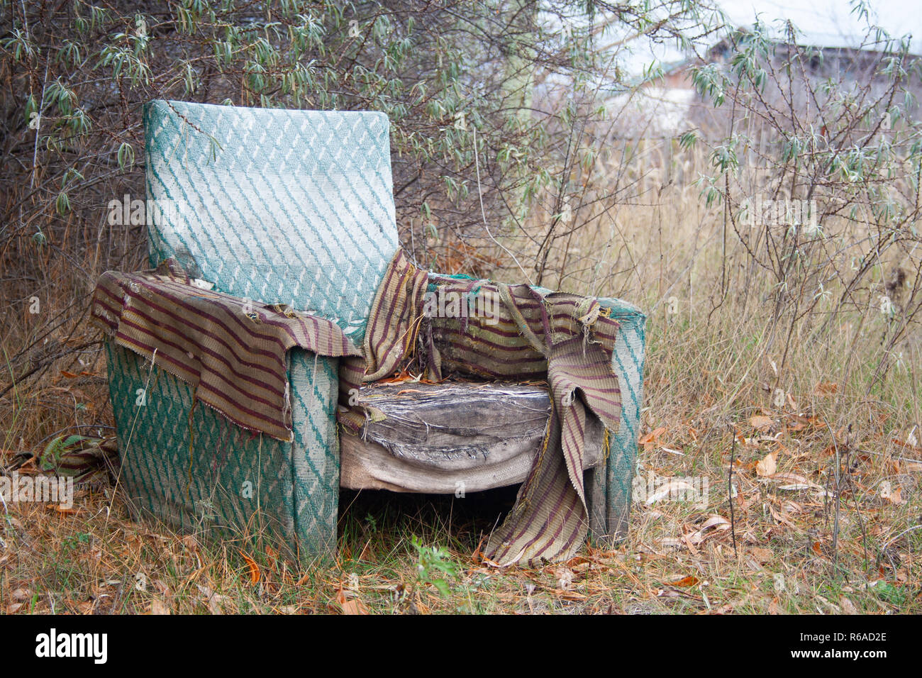 Old discarded and tattered armchair in the grass Stock Photo - Alamy
