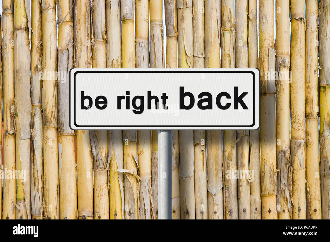 Be right back written on road sign against a bamboo fence - concept ...