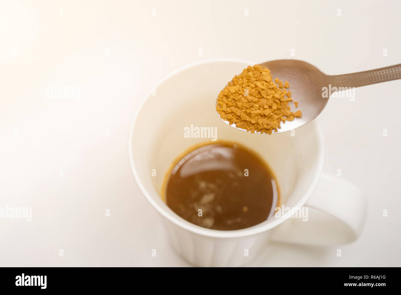 Coffee spoon and a cup of white coffee with flare lighting Stock Photo ...