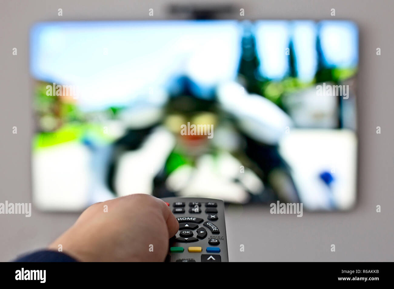 Tv and hand pressing remote control Stock Photo - Alamy
