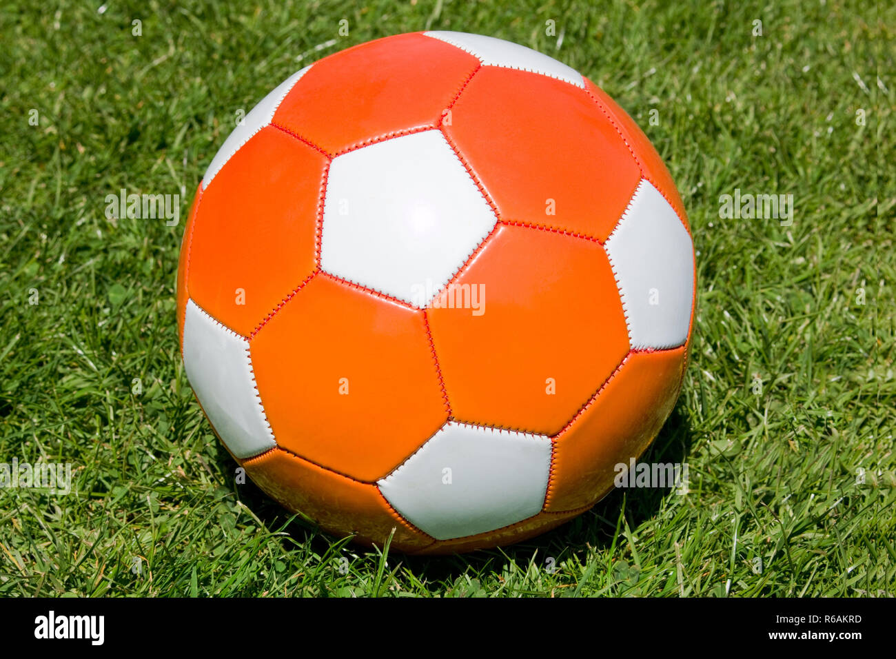 Orange Soccer Ball On Green Grass Stock Photo - Alamy
