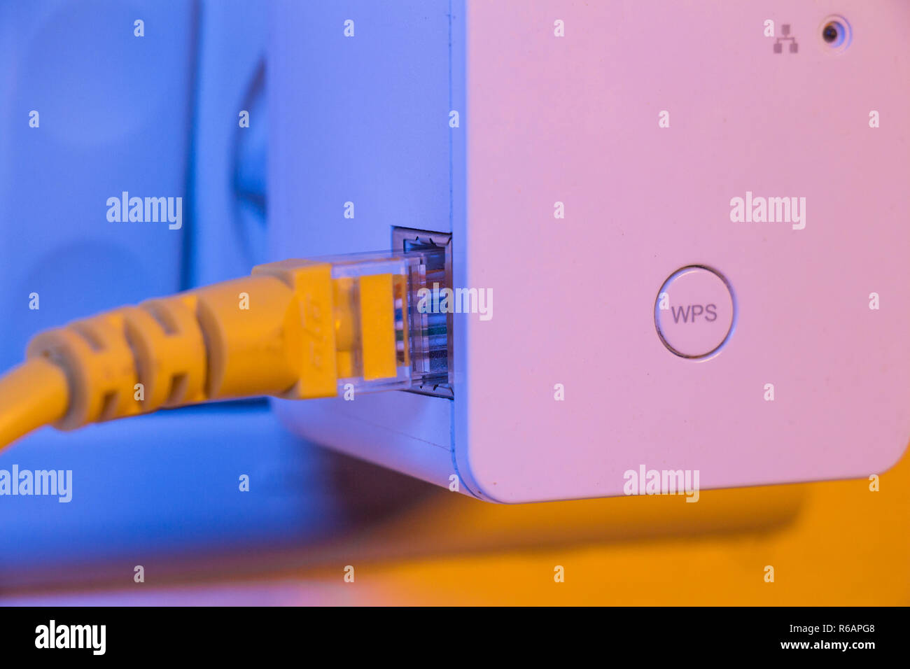 WiFi extender in electrical socket on the wall with ethernet cable ...