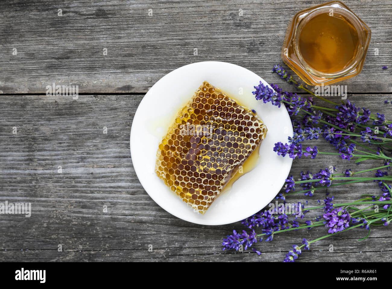 Honey with lavender flowers and honeycombs on rustic wooden table ...
