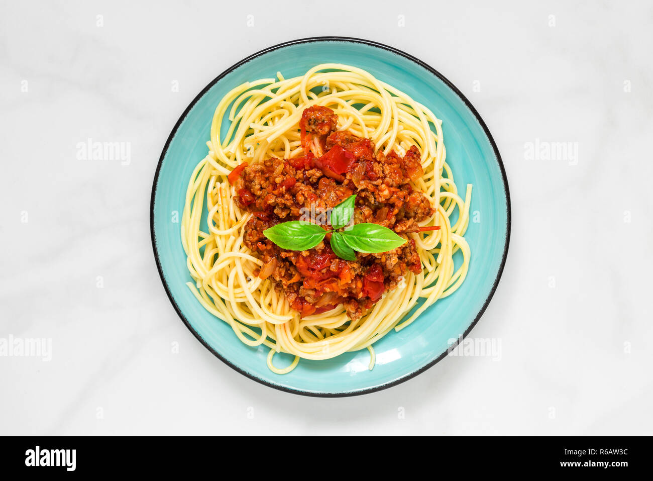 Spaghetti bolognese on a blue plate on white marble table. healthy food ...