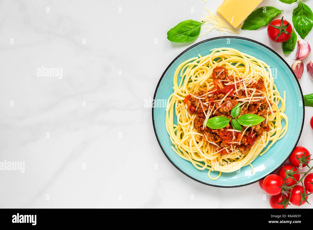 pasta spaghetti bolognese on a blue plate on white marble table ...