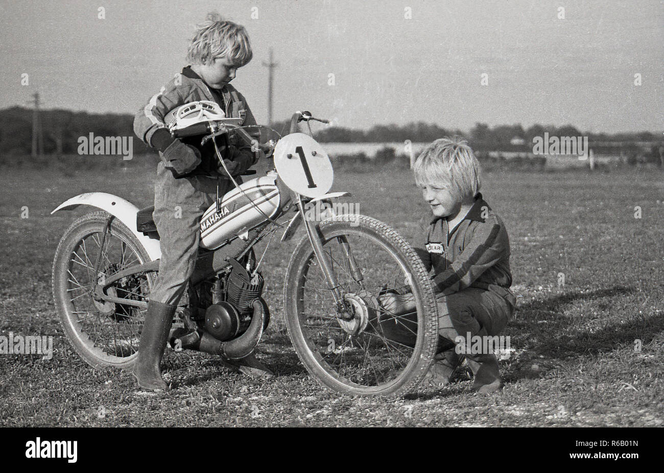 1970s, historical, outside in an open field, a a young boy standing on ...