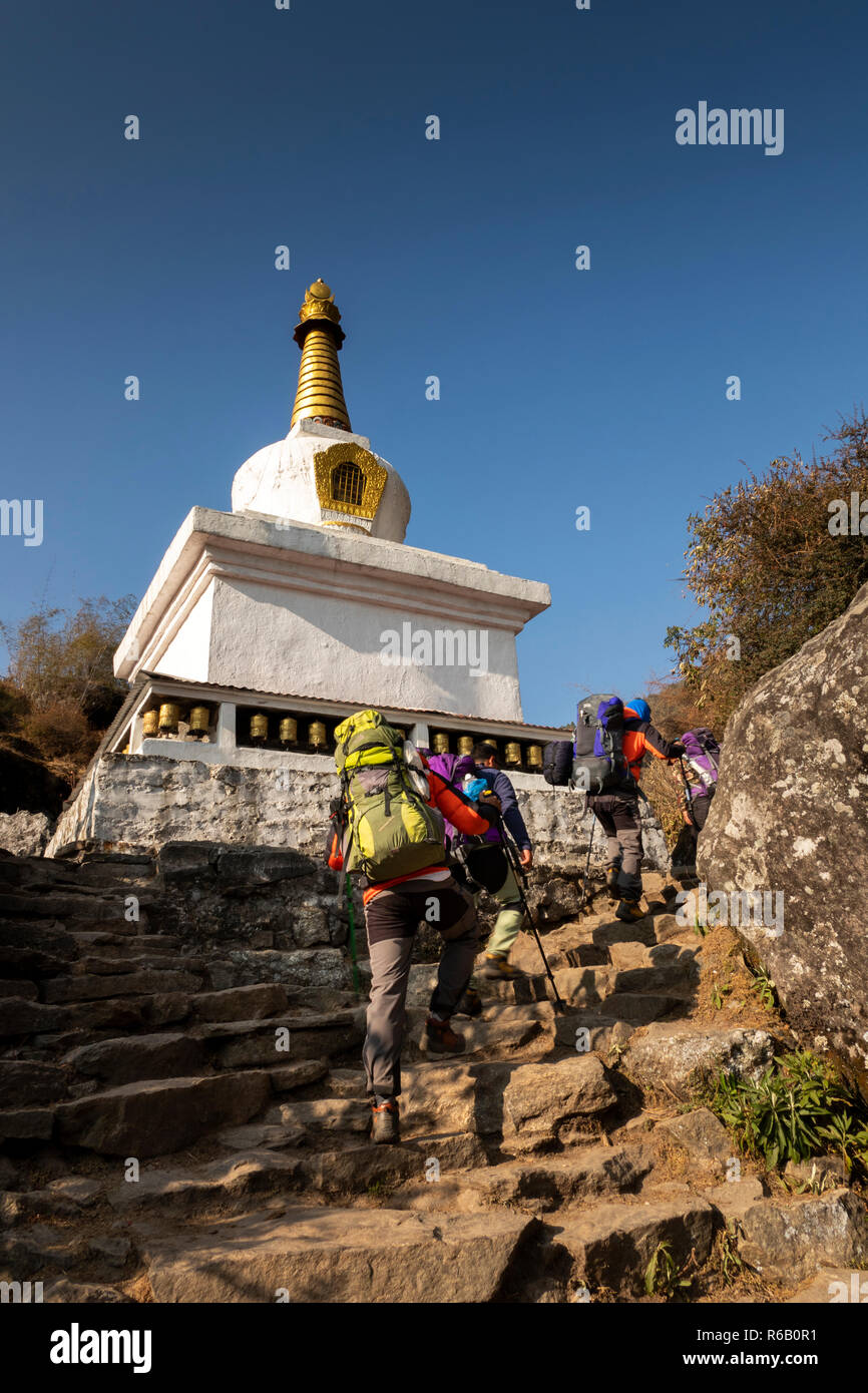 Nepal, Nurning, trekkers climbing stone steps past Buddhist chorten on ...
