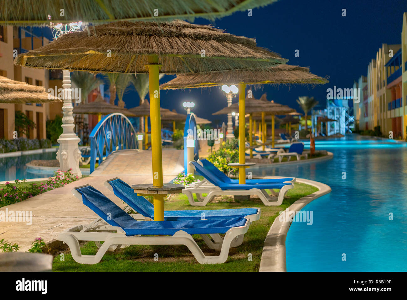 luxury resort with pool at night view. hotel outdoor landscape with ...