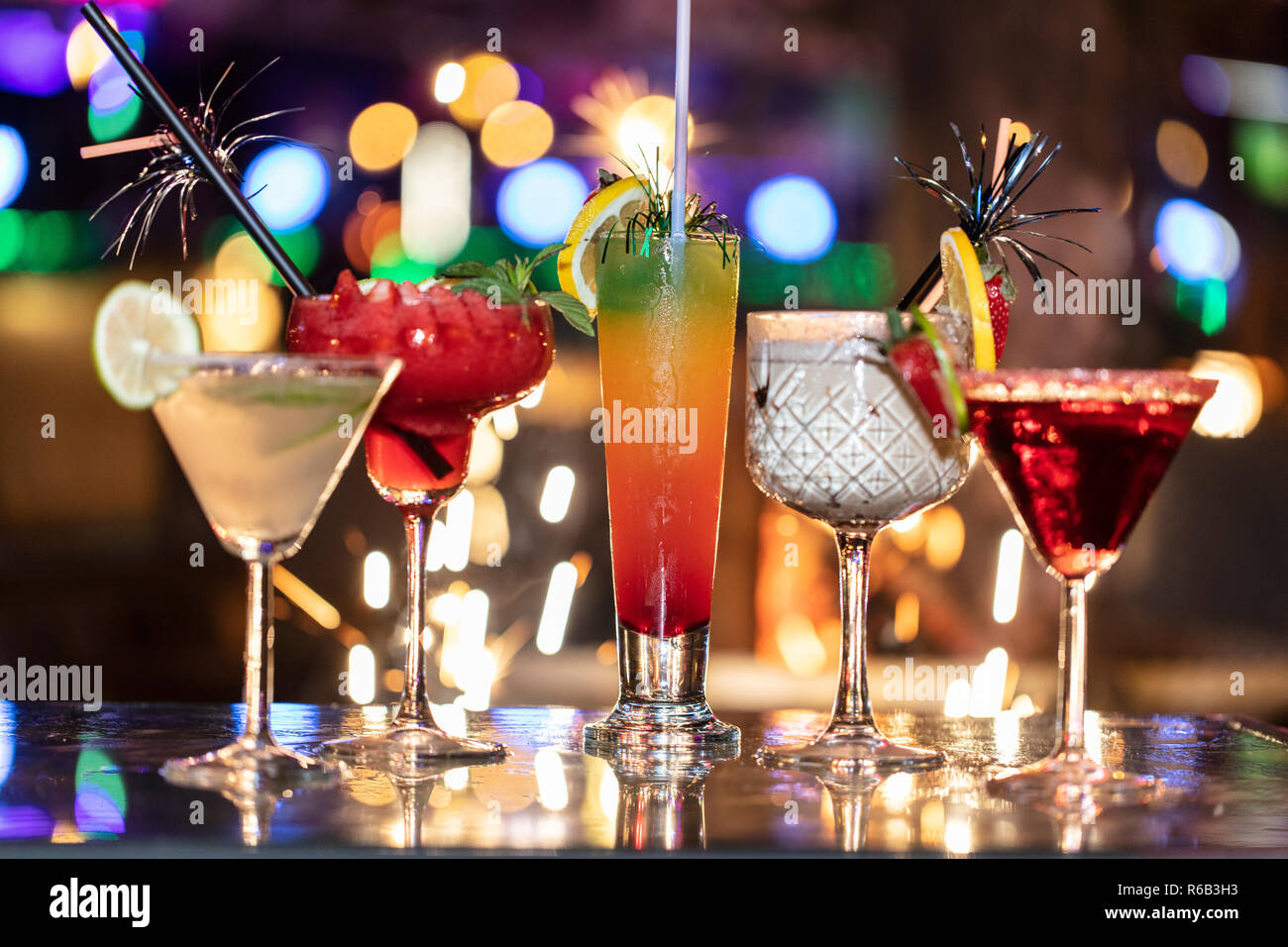 Alcoholic cocktail row on bar table, colorful party drinks Stock Photo ...
