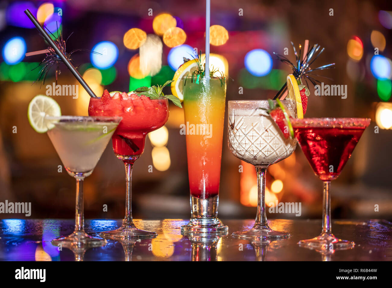 Alcoholic cocktail row on bar table, colorful party drinks Stock Photo ...