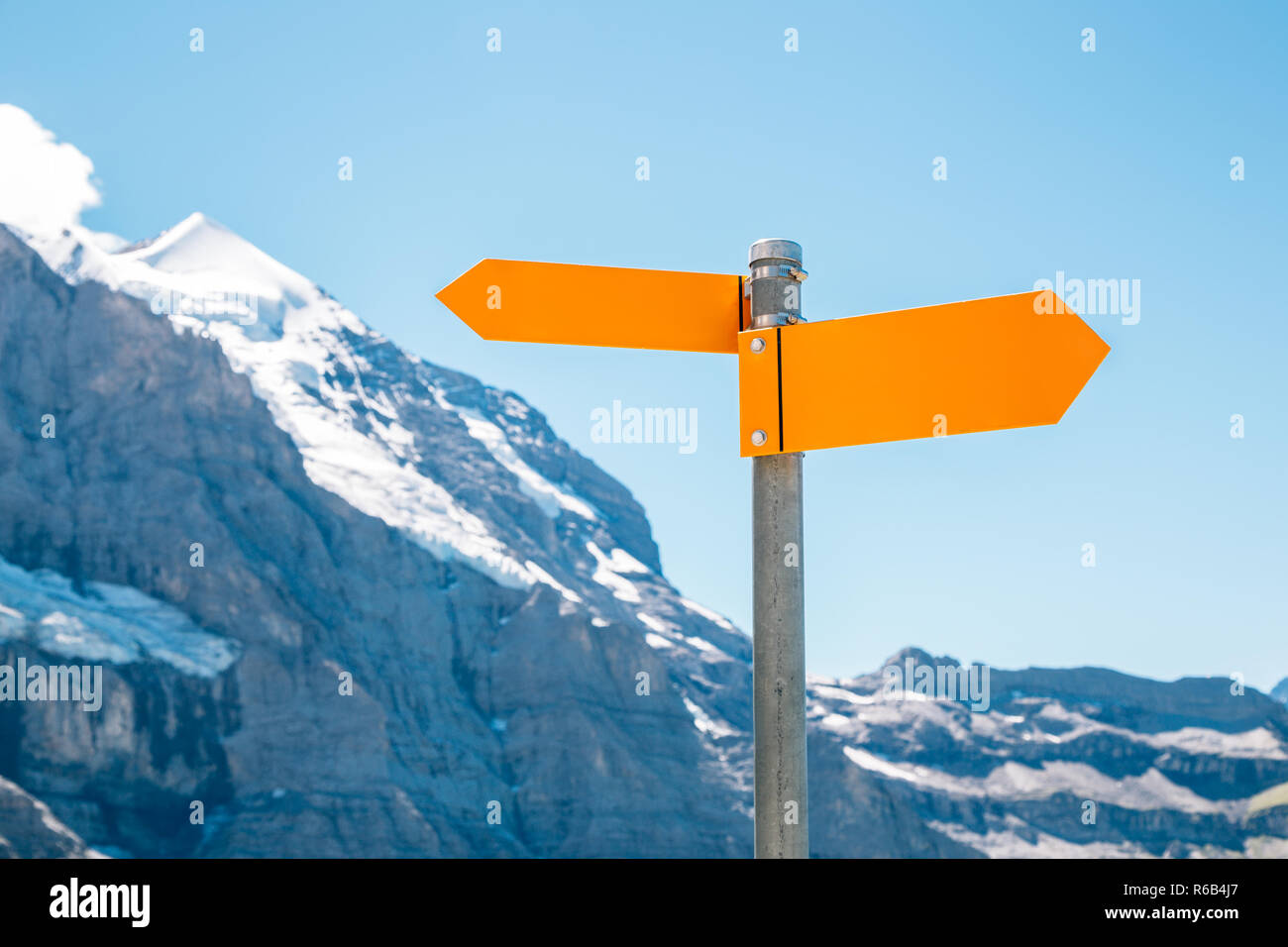 Arrow direction sign with snowy mountain Stock Photo - Alamy