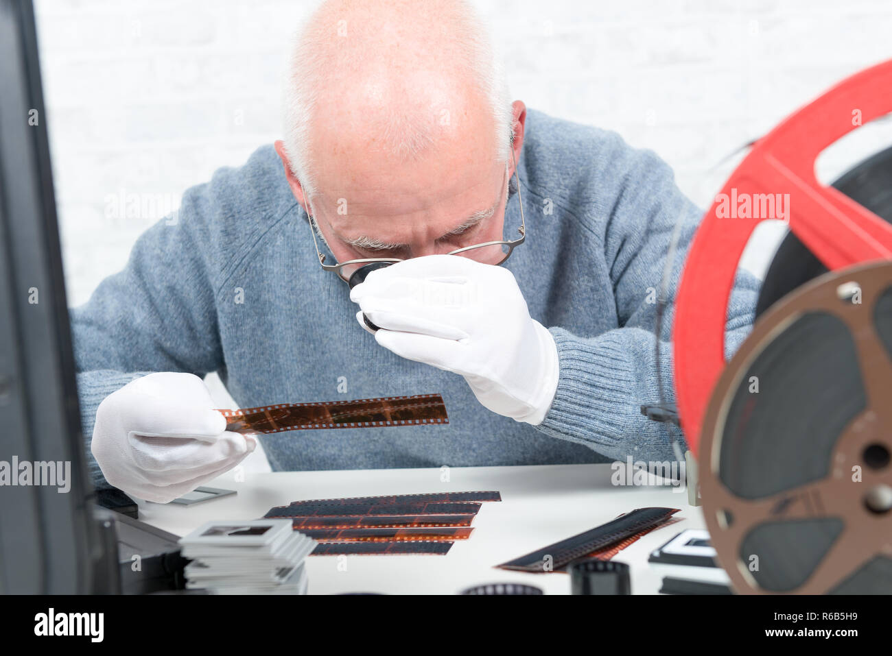 photographer looking at negative film with a magnifying glass Stock ...