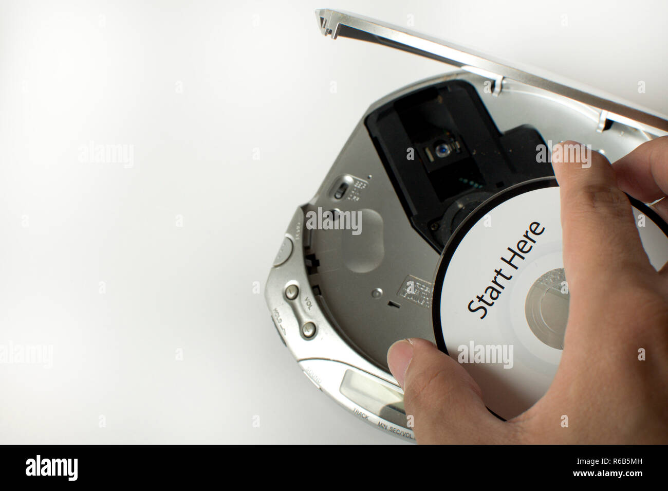 A man is inserting a cd in a cd player with a start here message Stock ...