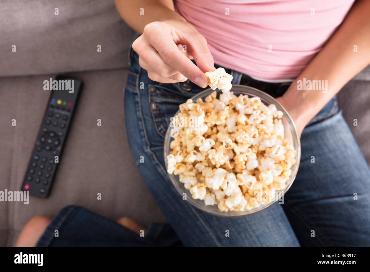 Woman Sitting On Sofa Eating Popcorn Stock Photo - Alamy
