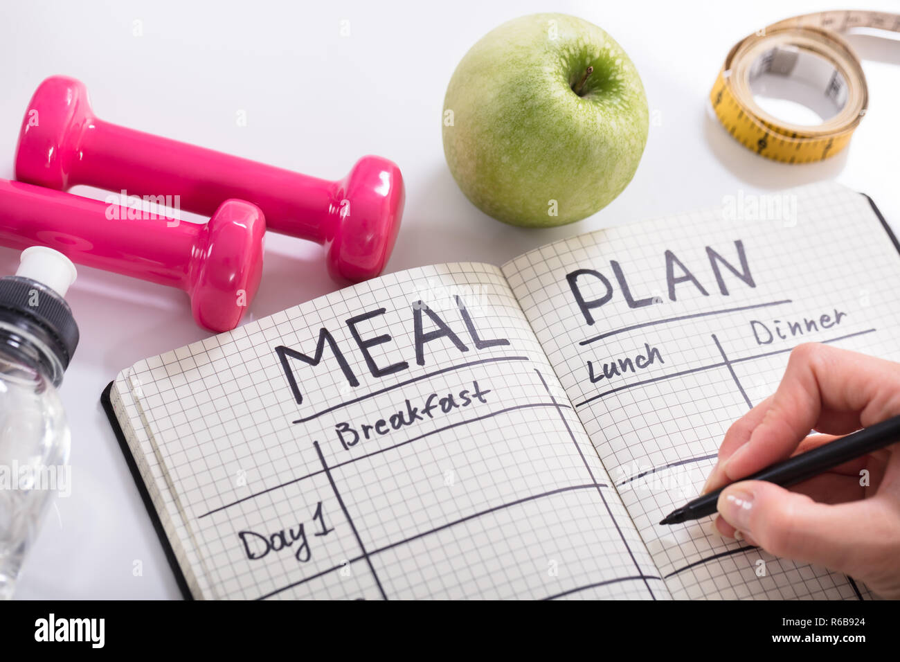 Filling Meal Plan In Notebook At Wooden Desk Stock Photo - Alamy