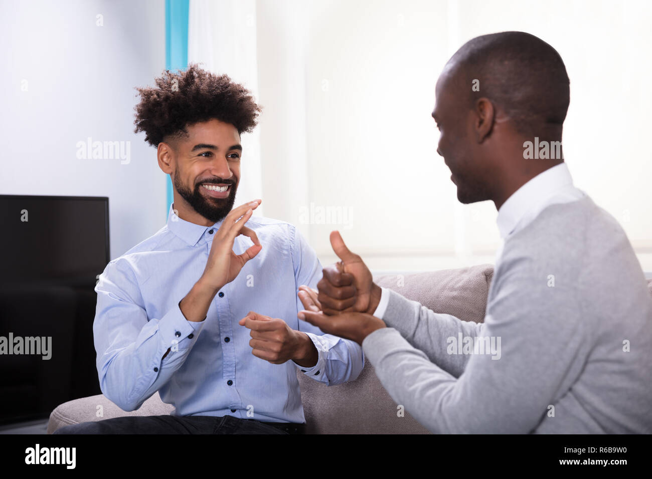 Two Happy Men Making Sign Language Stock Photo - Alamy
