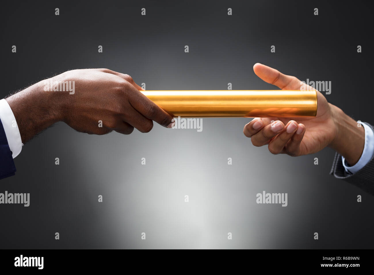 Man Passing The Golden Baton To His Partner Stock Photo - Alamy