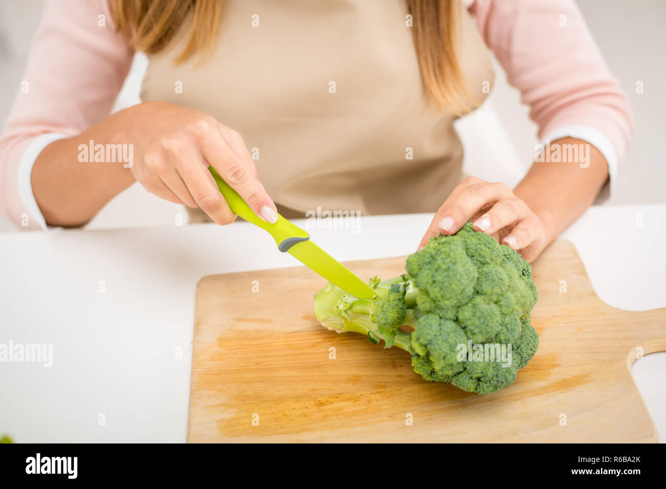 Close-up of a female hands cutting broccoli on the kitchen board Stock ...