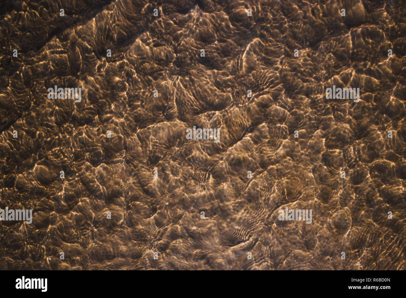 Sea water flowing over sand leaving abstract patterns, natural ...