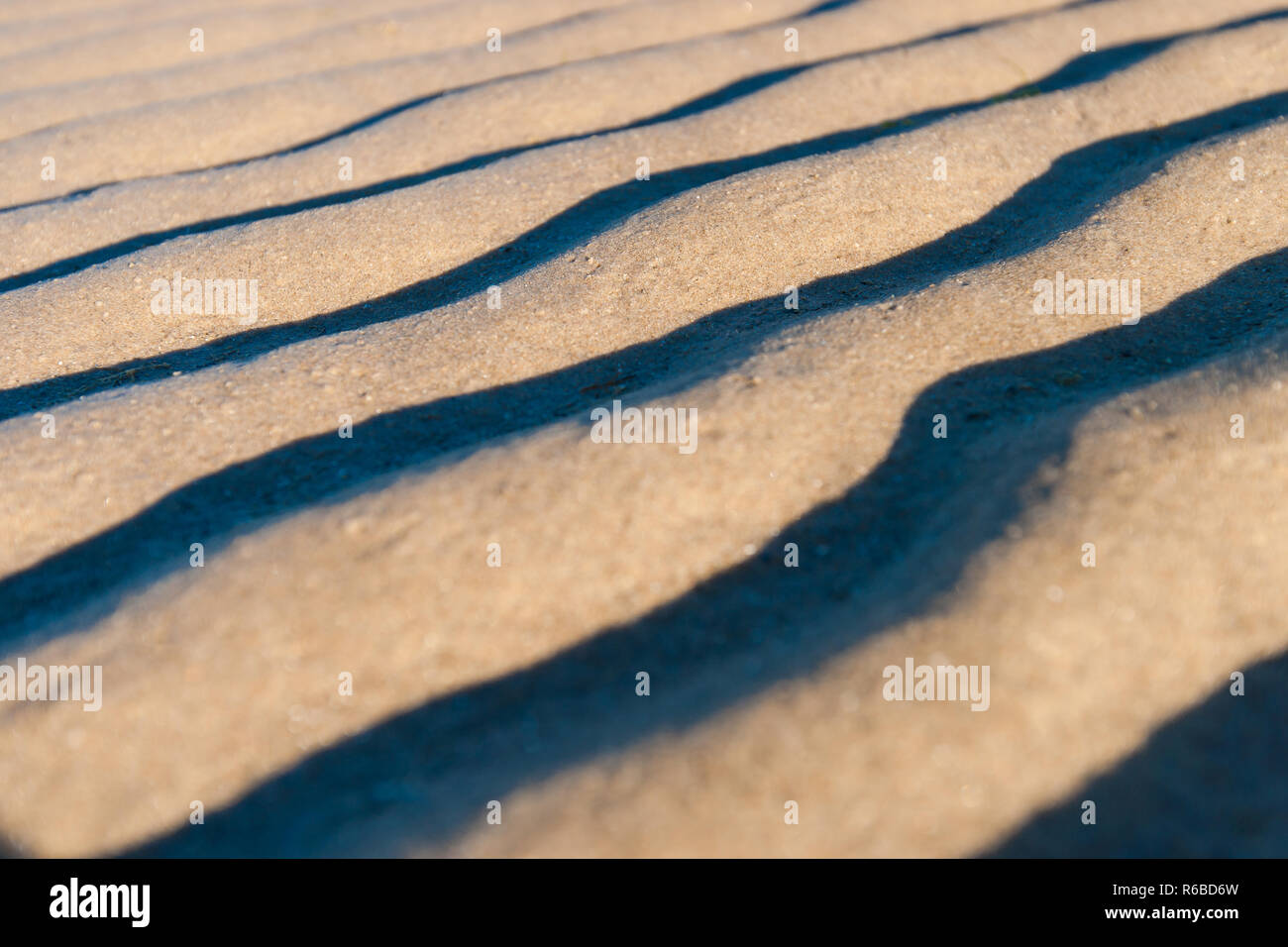 Sea water flowing over sand leaving abstract patterns, natural ...