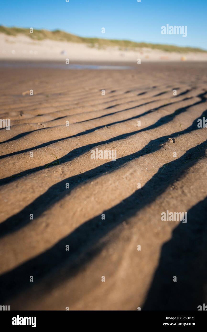 Sea water flowing over sand leaving abstract patterns, natural ...