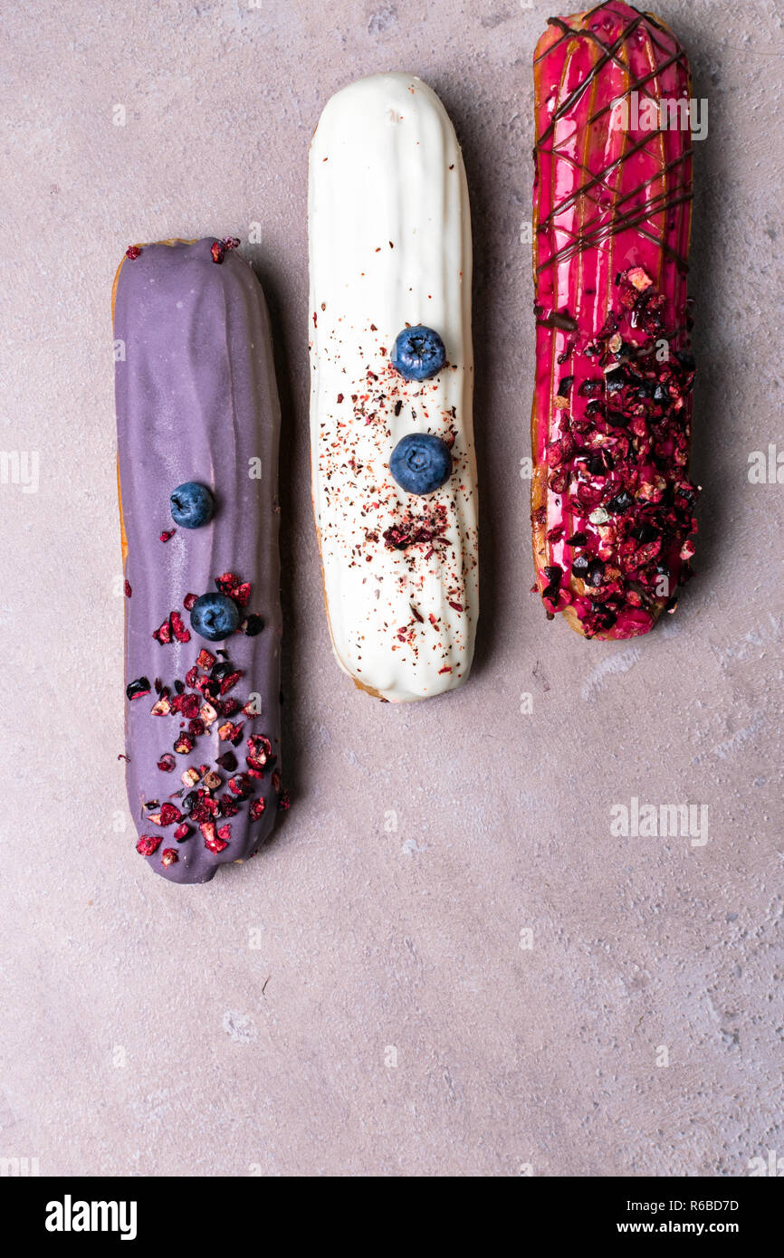 sweet and colorful eclair on black background. french eclair. top view ...