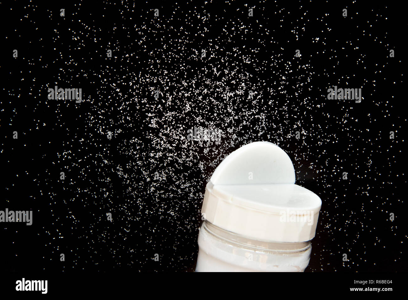 Cloud of white rock salt with jar pill bottle isolated on black ...