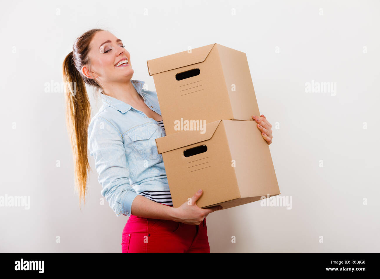 Woman moving in carrying cartons boxes. Young girl unpacking at new ...