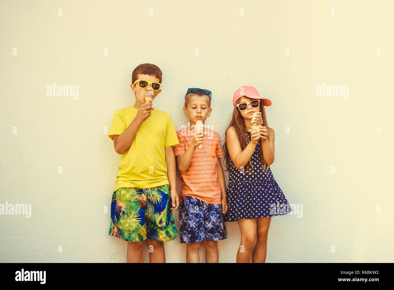 Kids eating gelato and soft serve ice cream. Boys and little girl in ...