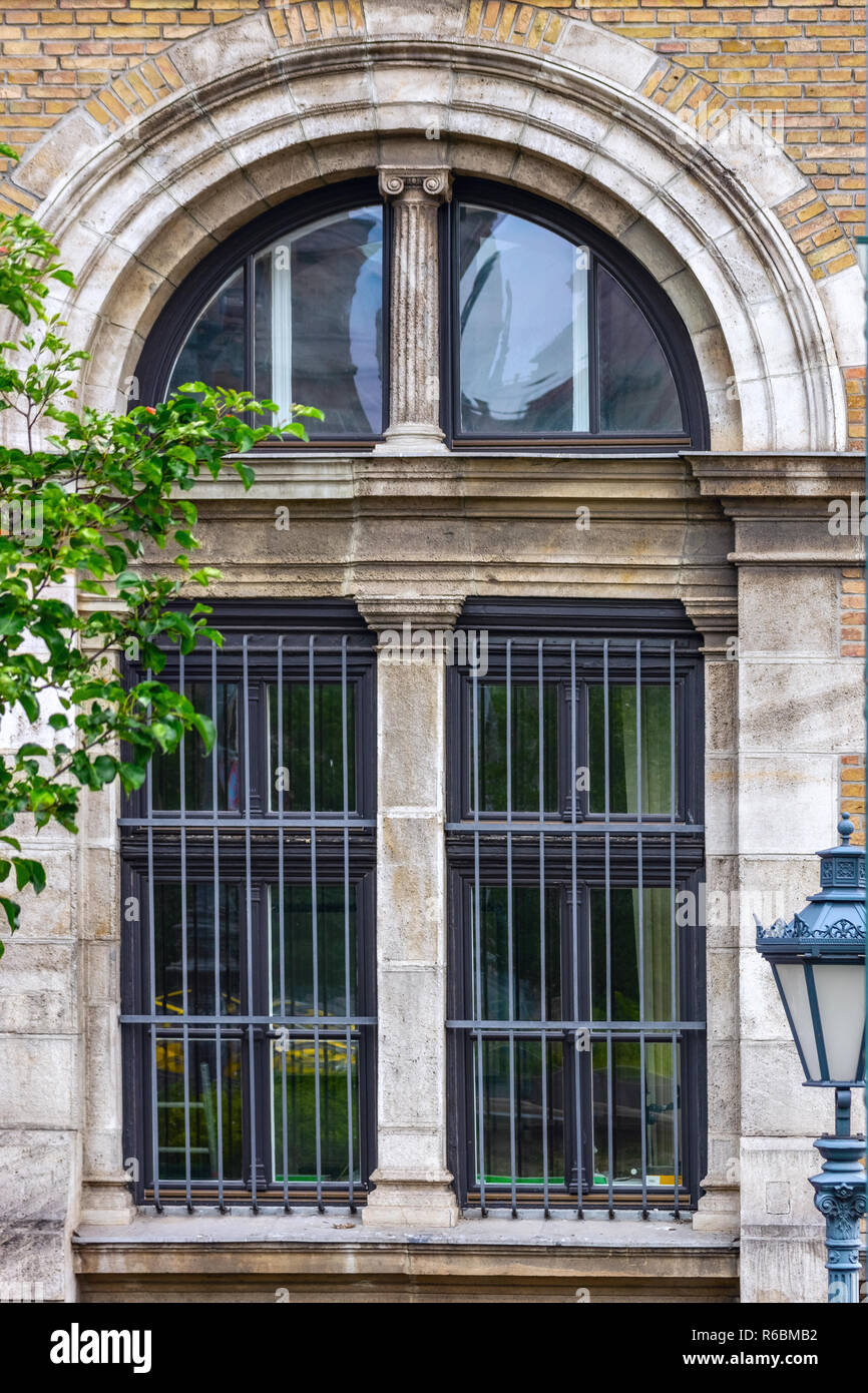 Rectangular window with a lattice and arched fragment with a column ...