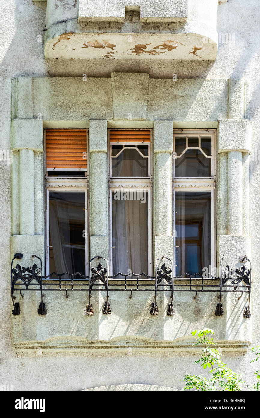 Triple window with columns and french balcony on grey wall background ...