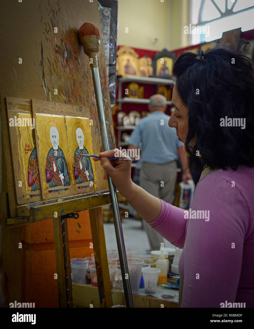 Woman painter paints icons in icon shop Stock Photo - Alamy