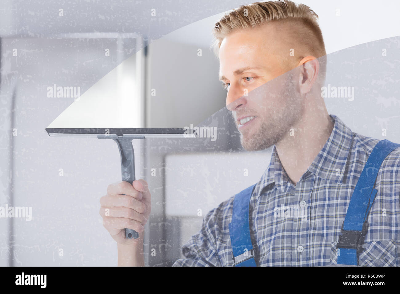 Worker Cleaning Glass Window With Squeegee Stock Photo - Alamy