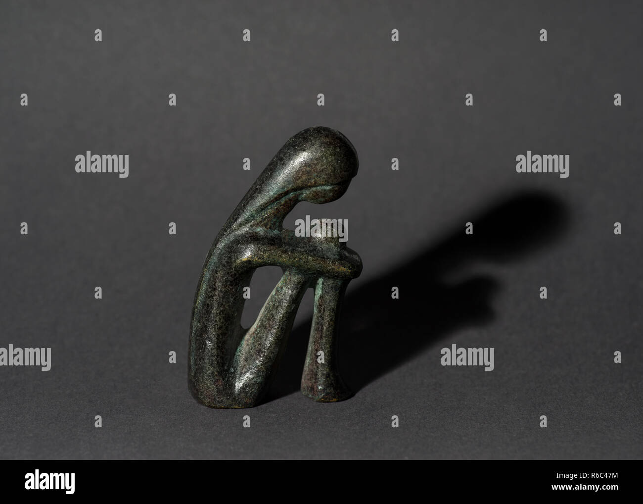 brass figure statue with dark shadow Stock Photo - Alamy