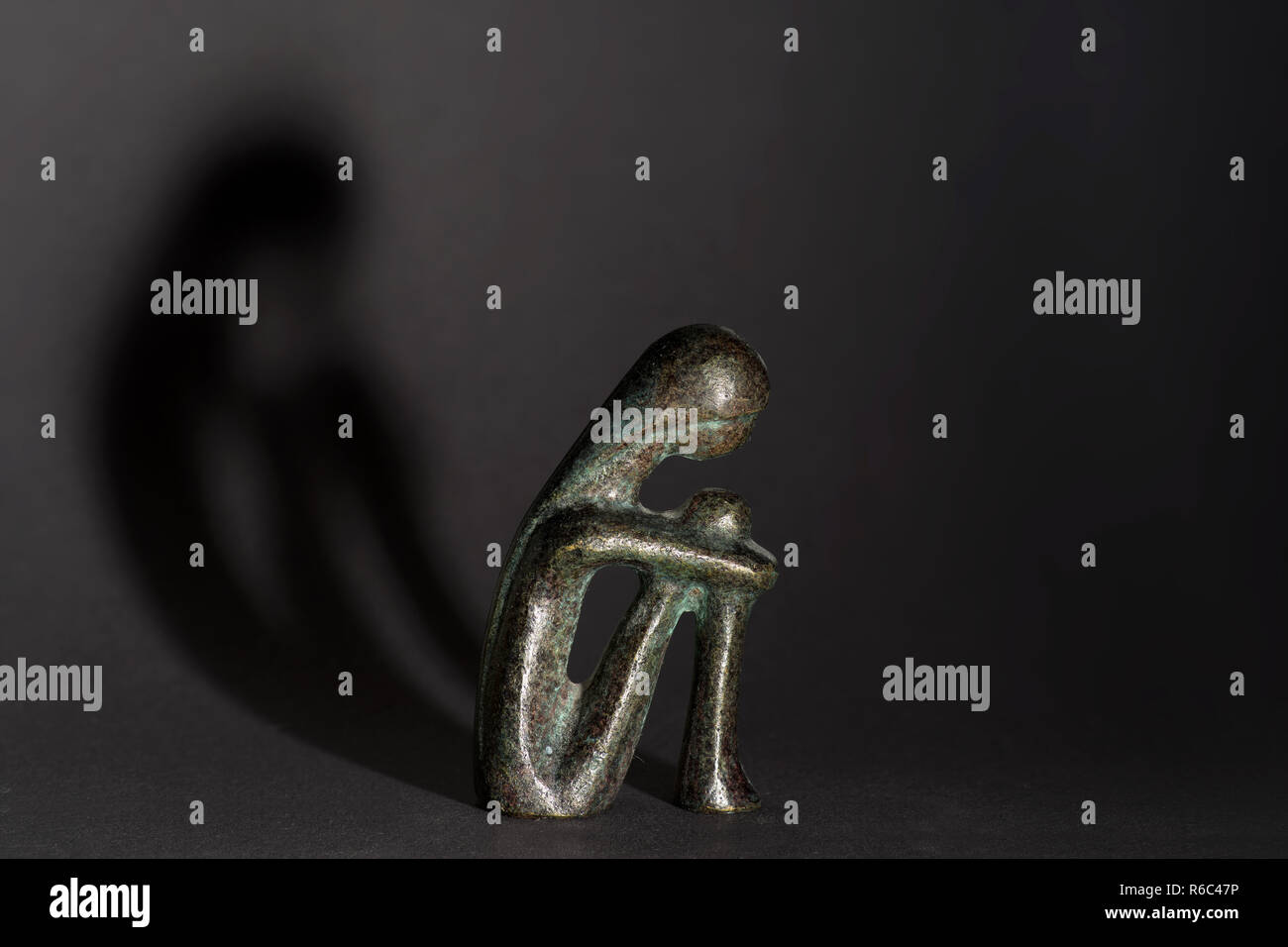 brass figure statue with dark shadow Stock Photo - Alamy