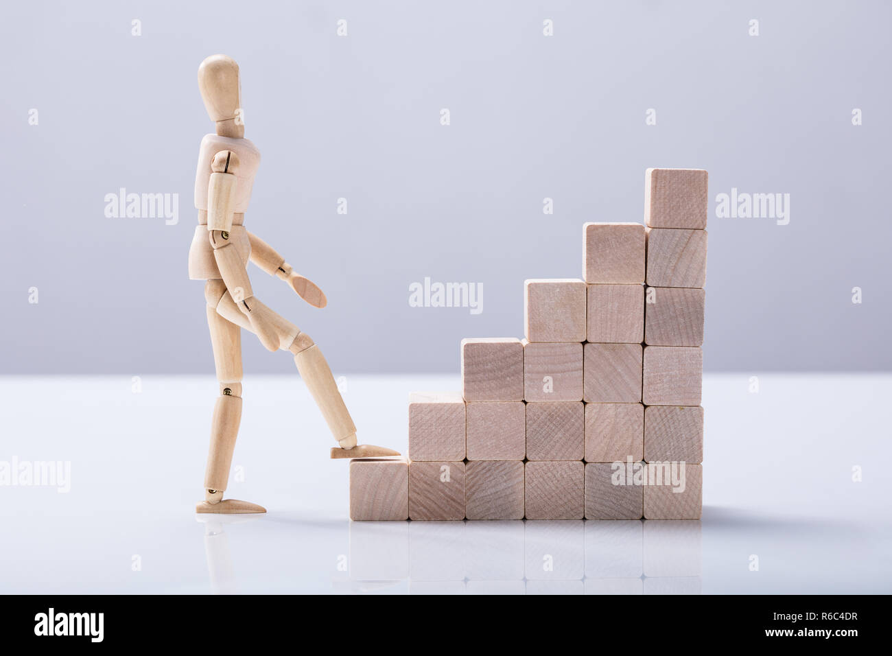 Side View Of A Wooden Figure Climbing Staircase Stock Photo - Alamy